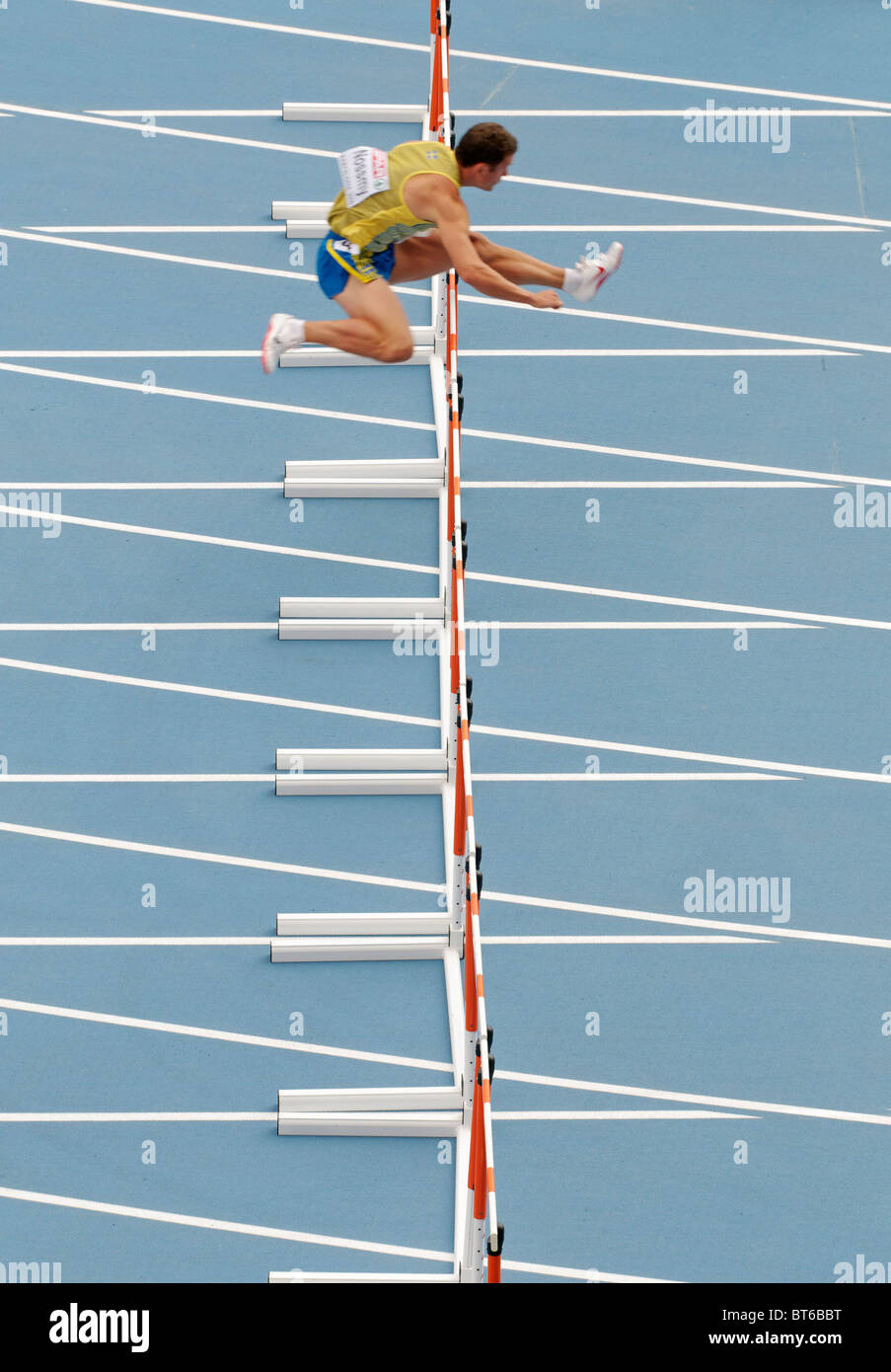 lone male sprinter jumps over hurdle during track and field event Stock ...