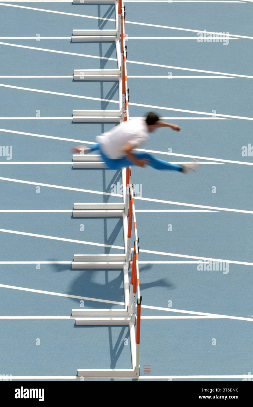 lone male sprinter jumps over hurdle during track and field event Stock ...