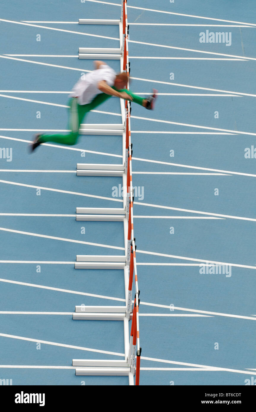 lone male sprinter jumps over hurdle during track and field event Stock ...