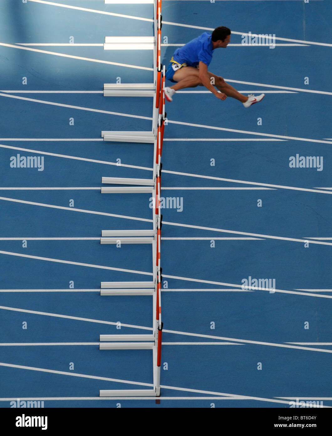 lone male sprinter jumps over hurdle during track and field event Stock ...