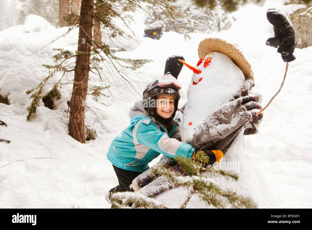 Smiling girl hugging snowman Stock Photo - Alamy