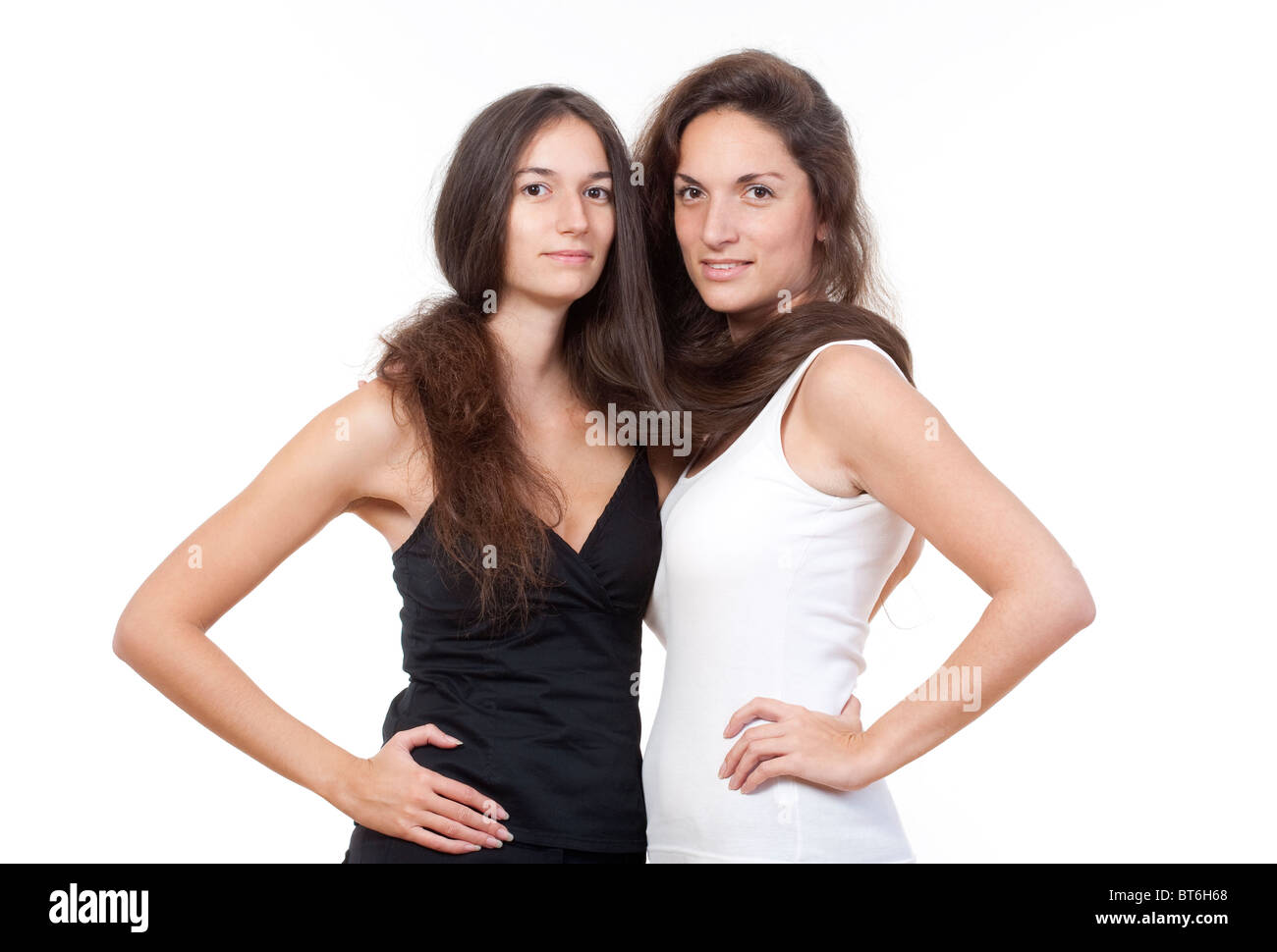 two sisters with long brown hair holding each other, looking Stock ...