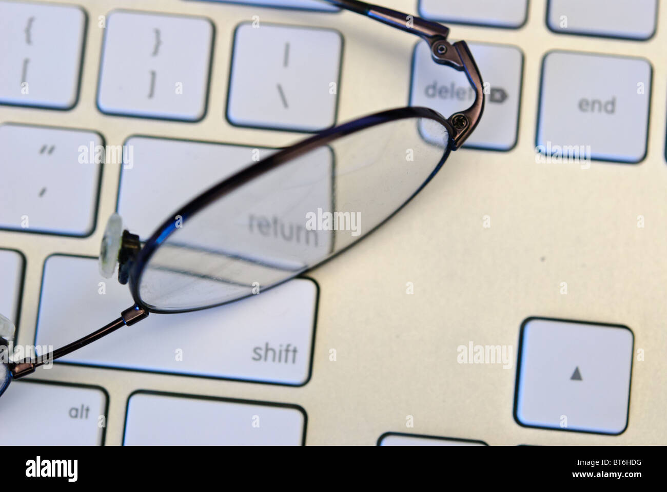 A spectacle is seen on a computer keyboard Stock Photo - Alamy