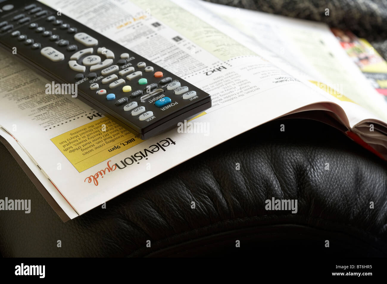tv remote control sitting on top of televisions listings magazine on ...