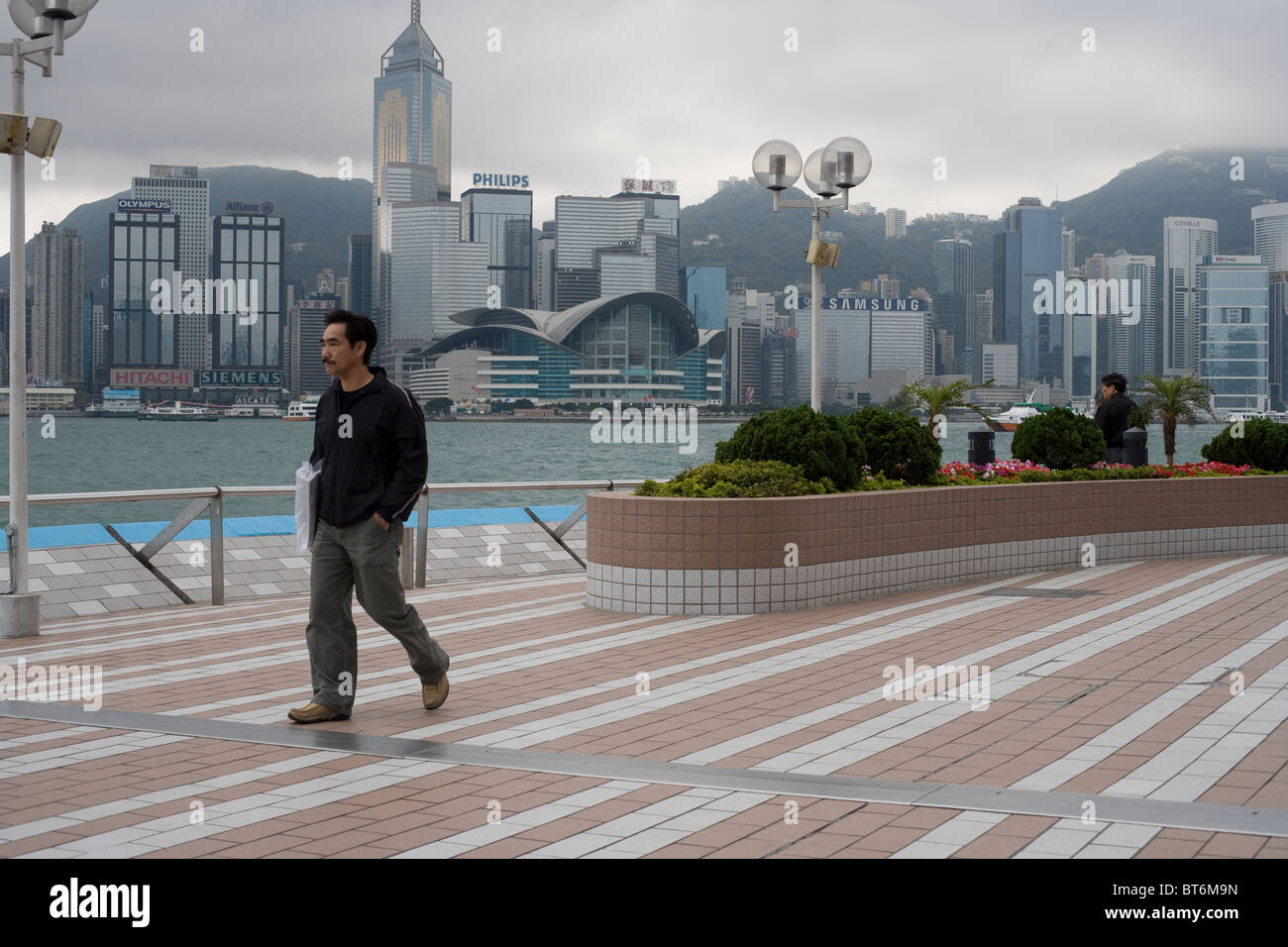 Man walking Tsim Sha Tsui waterfront with Victoria Harbour view Stock ...