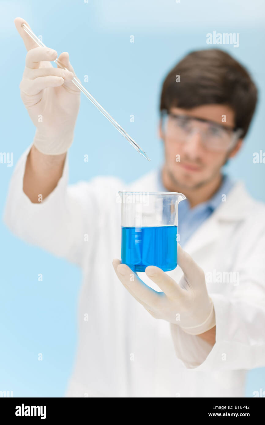 Chemistry experiment - scientist in laboratory, wear protective eye ...