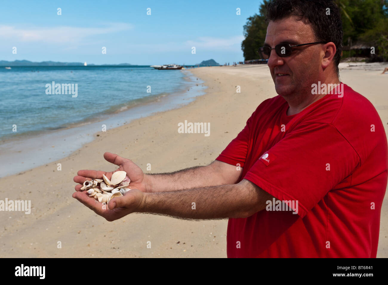 Man with shell on the beach Stock Photo - Alamy