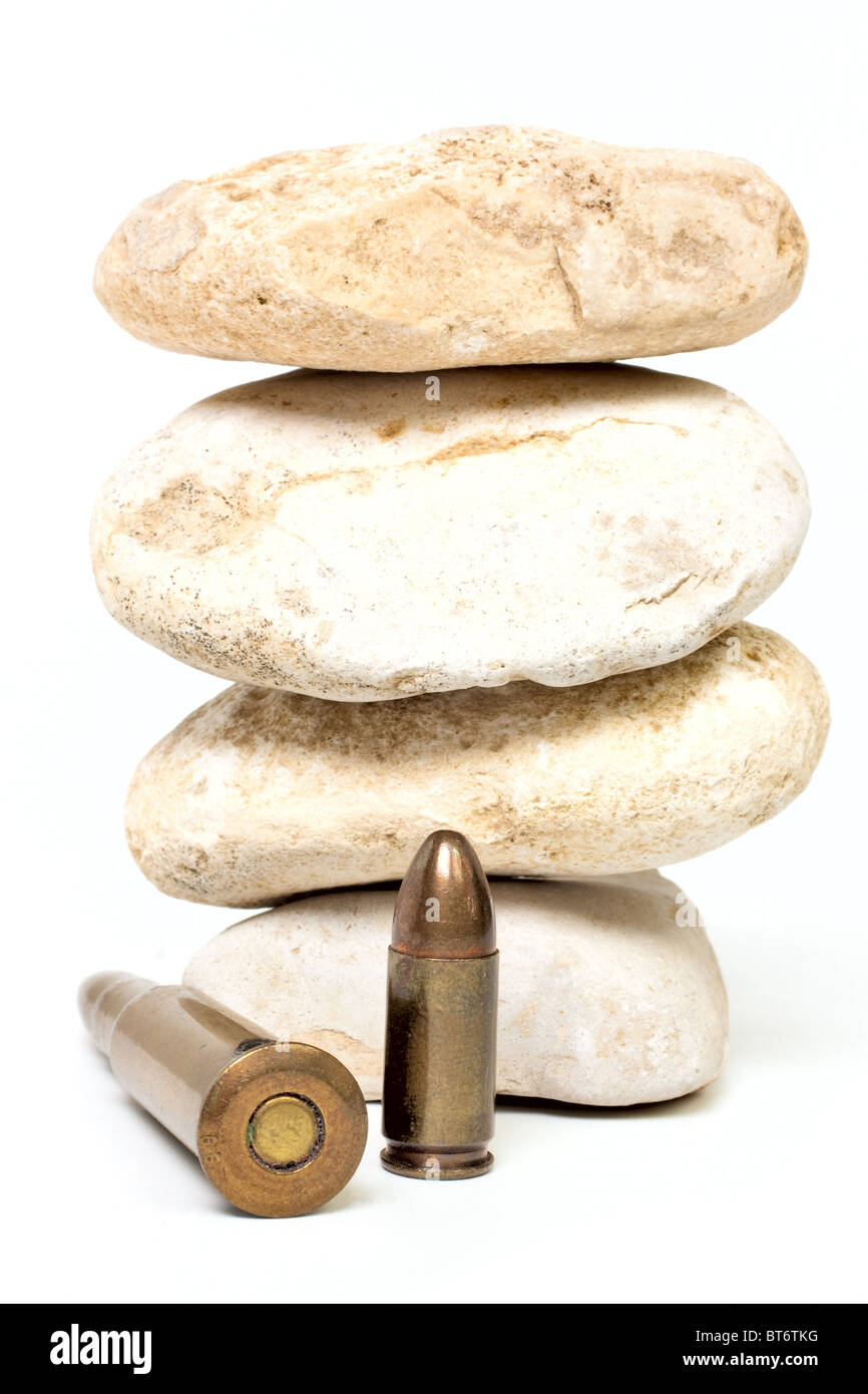 Bullet in front of stones pyramid isolated on white background Stock ...