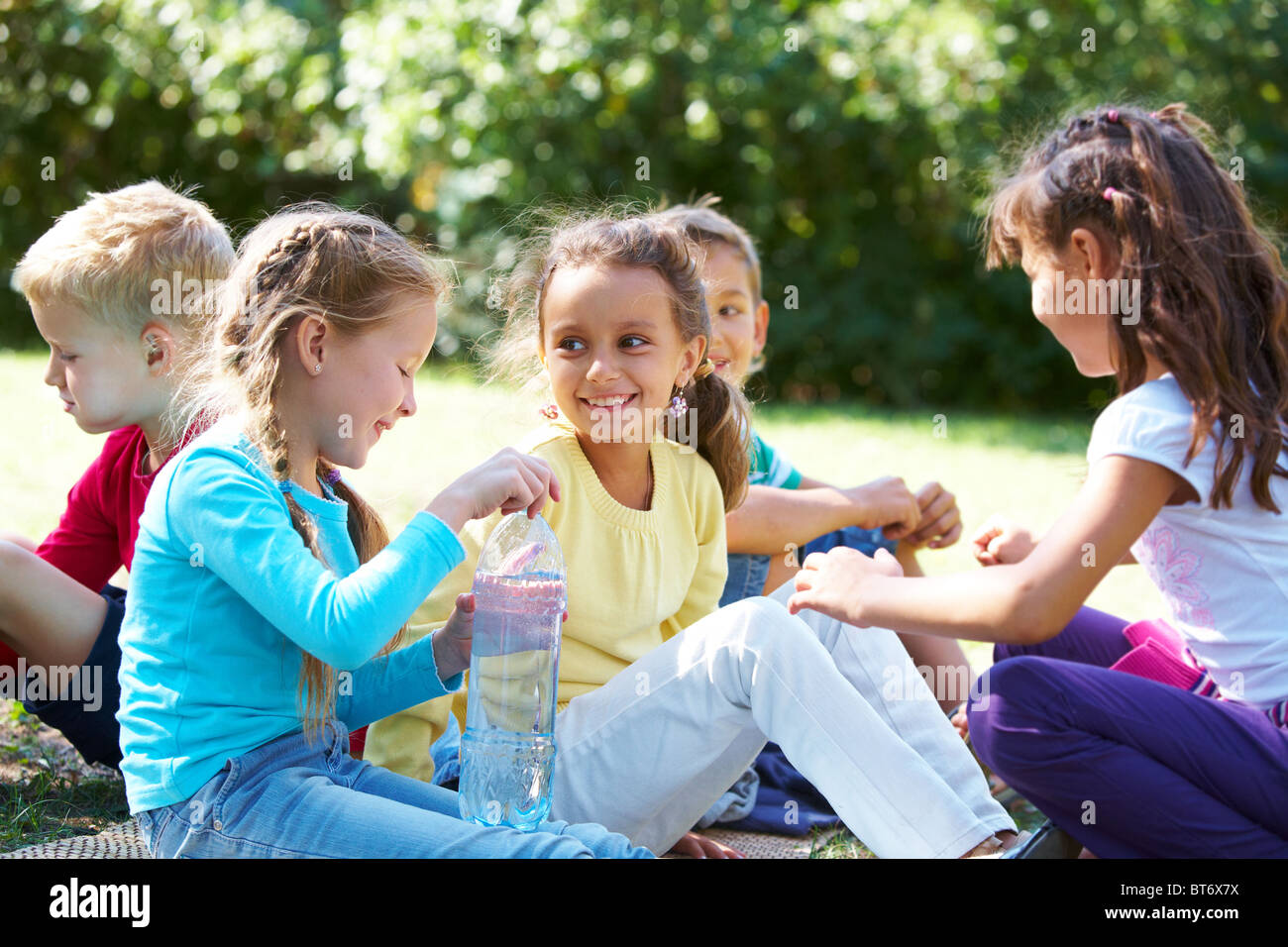 Portrait of happy friends chatting with each other in park Stock Photo ...