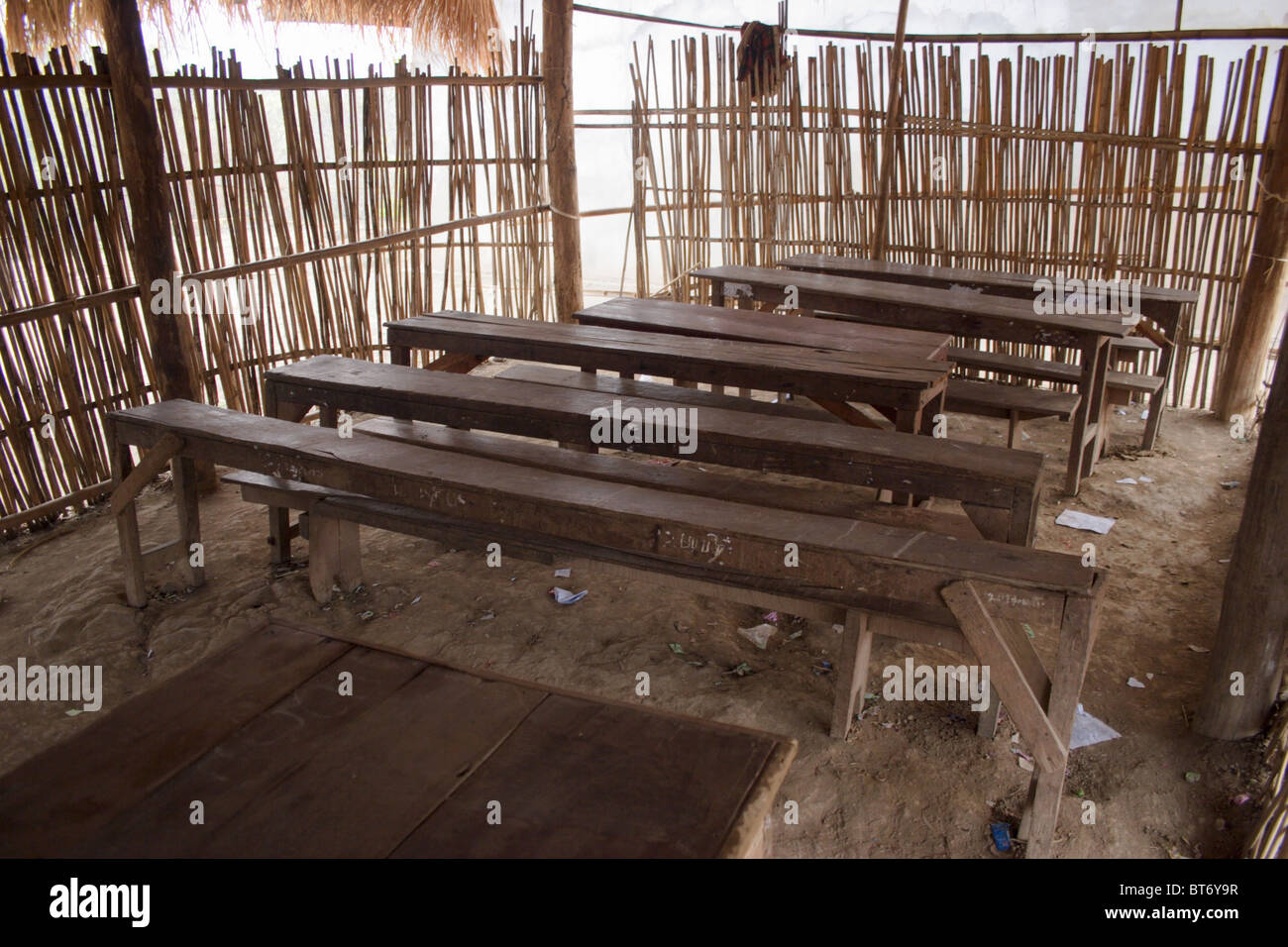 Old wooden tables in poor condition serve students and teachers in a ...