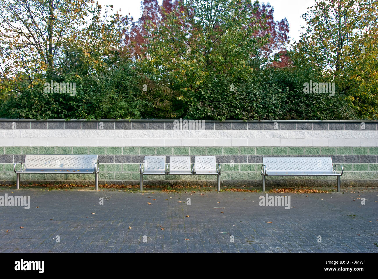 Metal benches against a wall Stock Photo - Alamy