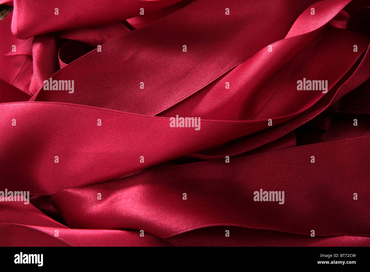 Red satin ribbons in a messy mess texture background Stock Photo - Alamy