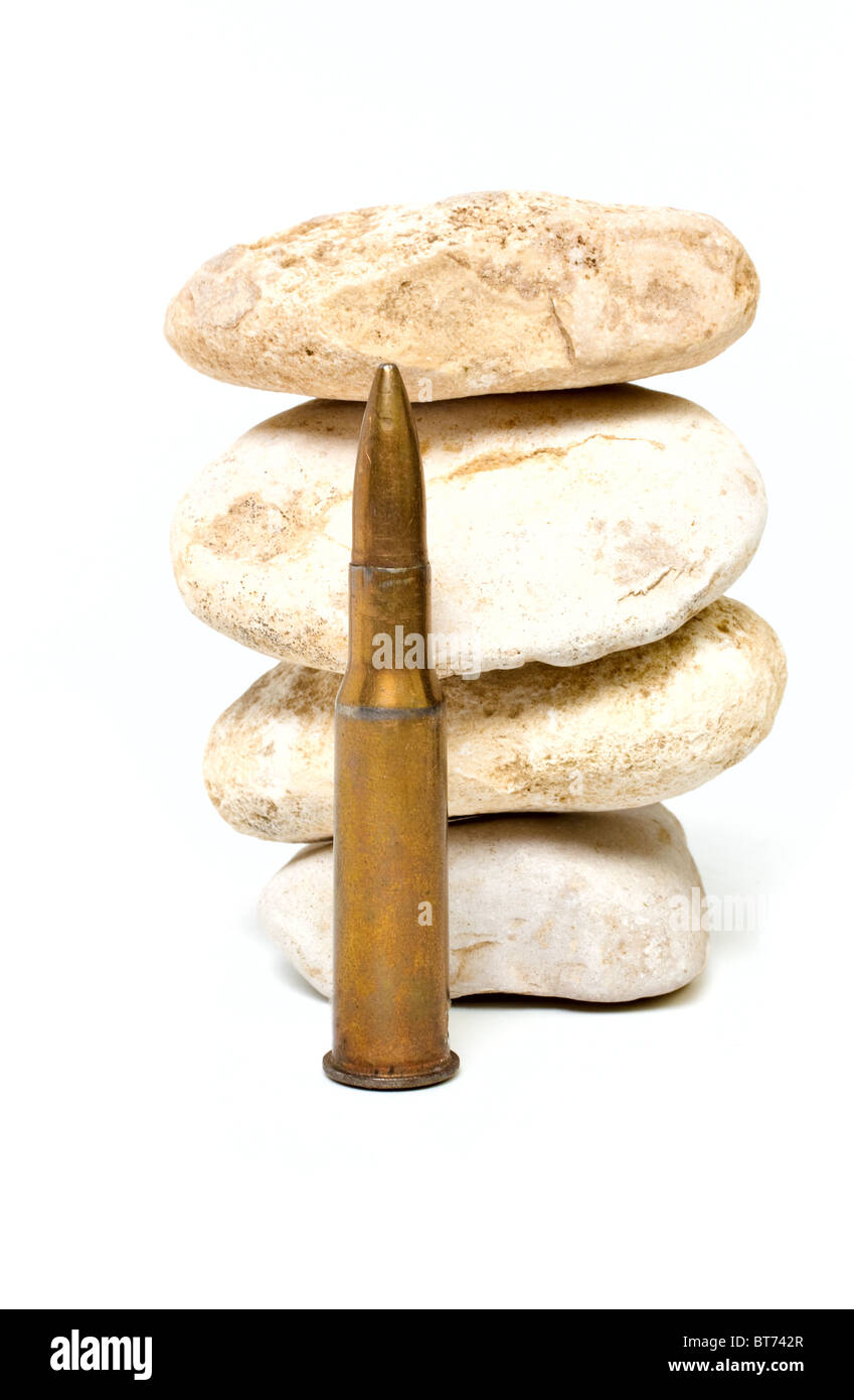 Bullet in front of stones pyramid isolated on white background Stock ...