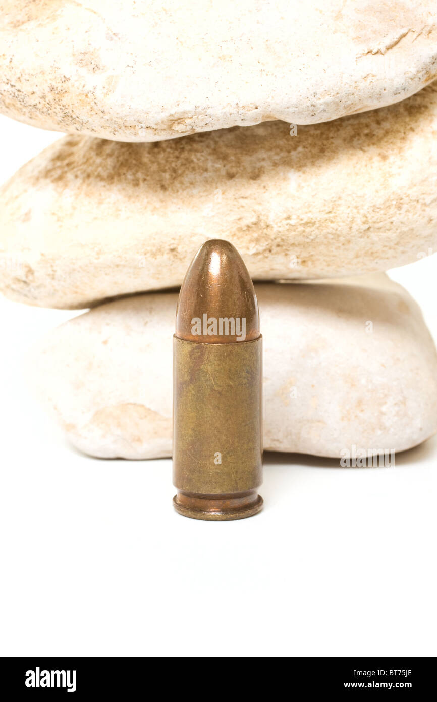 Bullet in front of stones pyramid isolated on white background Stock ...