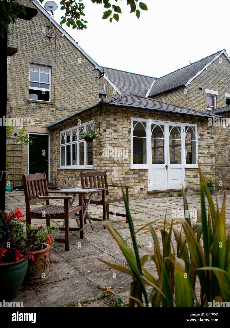 Wooden table and chairs on paved courtyard of traditional stone-built ...