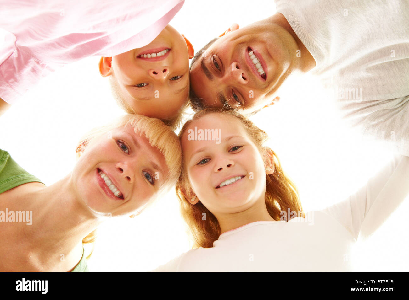 Below view of family members head by head smiling at camera Stock Photo ...