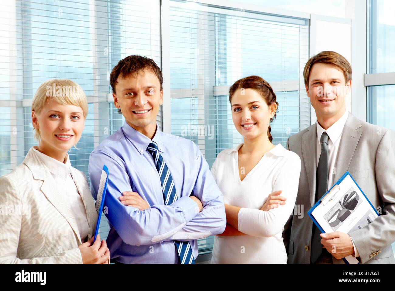 Portrait of smart business people standing next to each other and ...