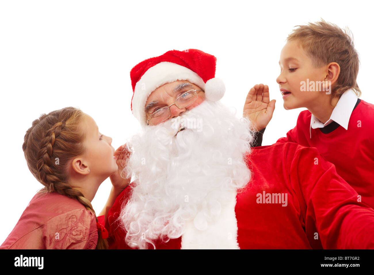Image of Santa listening to little boy and girl whispering their wishes ...