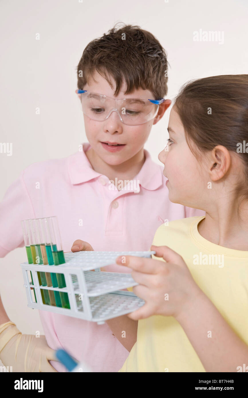 Boy wearing safety glasses talking about the experiment with a girl ...