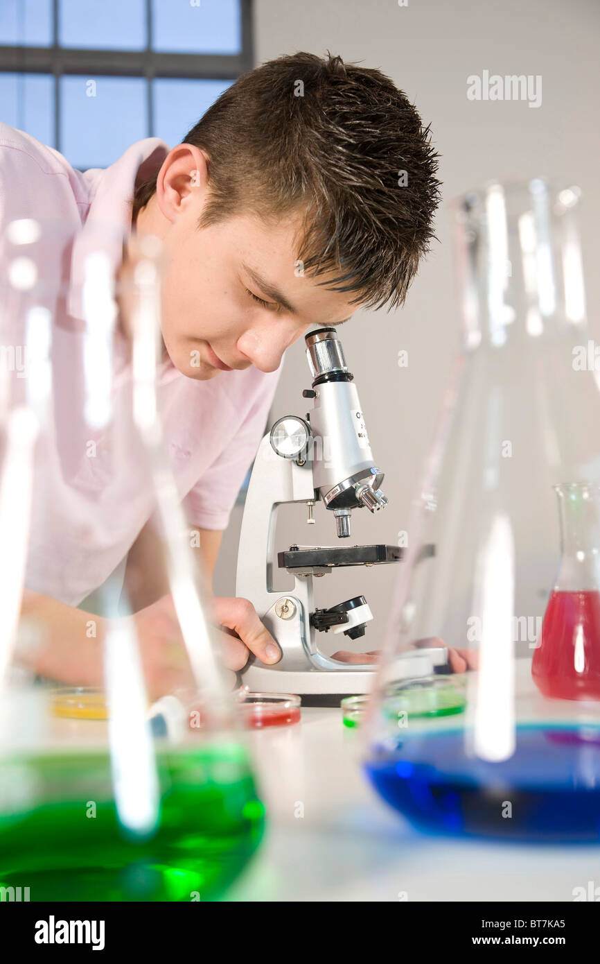 Teenage boy working in a laboratory, using a microscope Stock Photo - Alamy