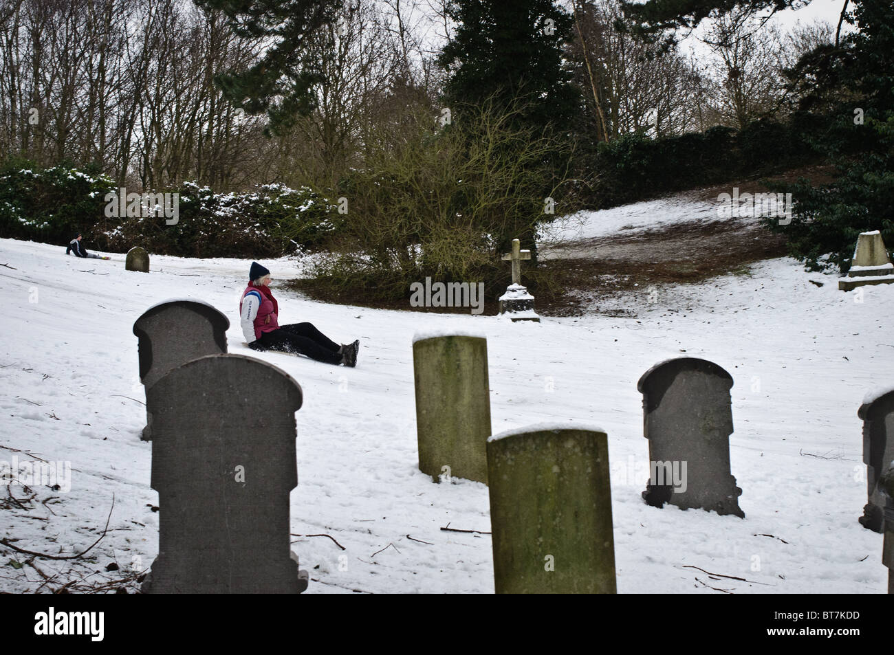 A woman sliding down a snowy slope. Netley Military Cemetery, Netley ...