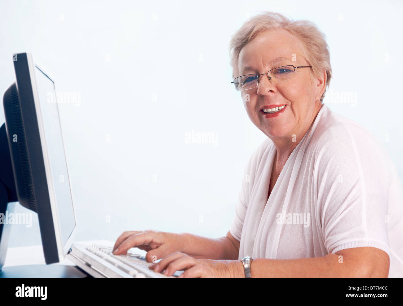 Portrait of kind and friendly woman typing and looking at camera Stock ...