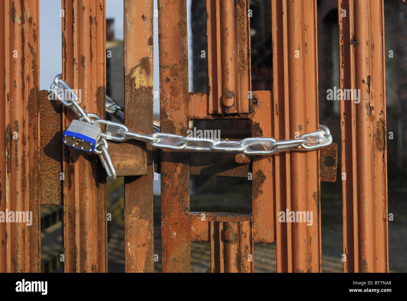 New padlock and chain on rusting gates Stock Photo - Alamy