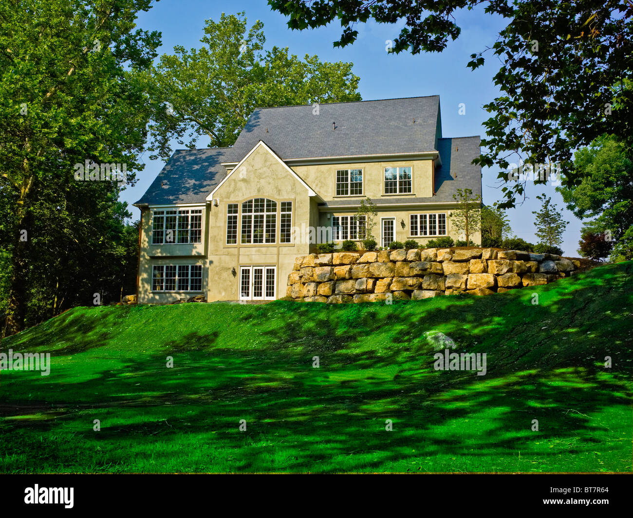Residential house multi windows, stone garden wall Stock Photo - Alamy
