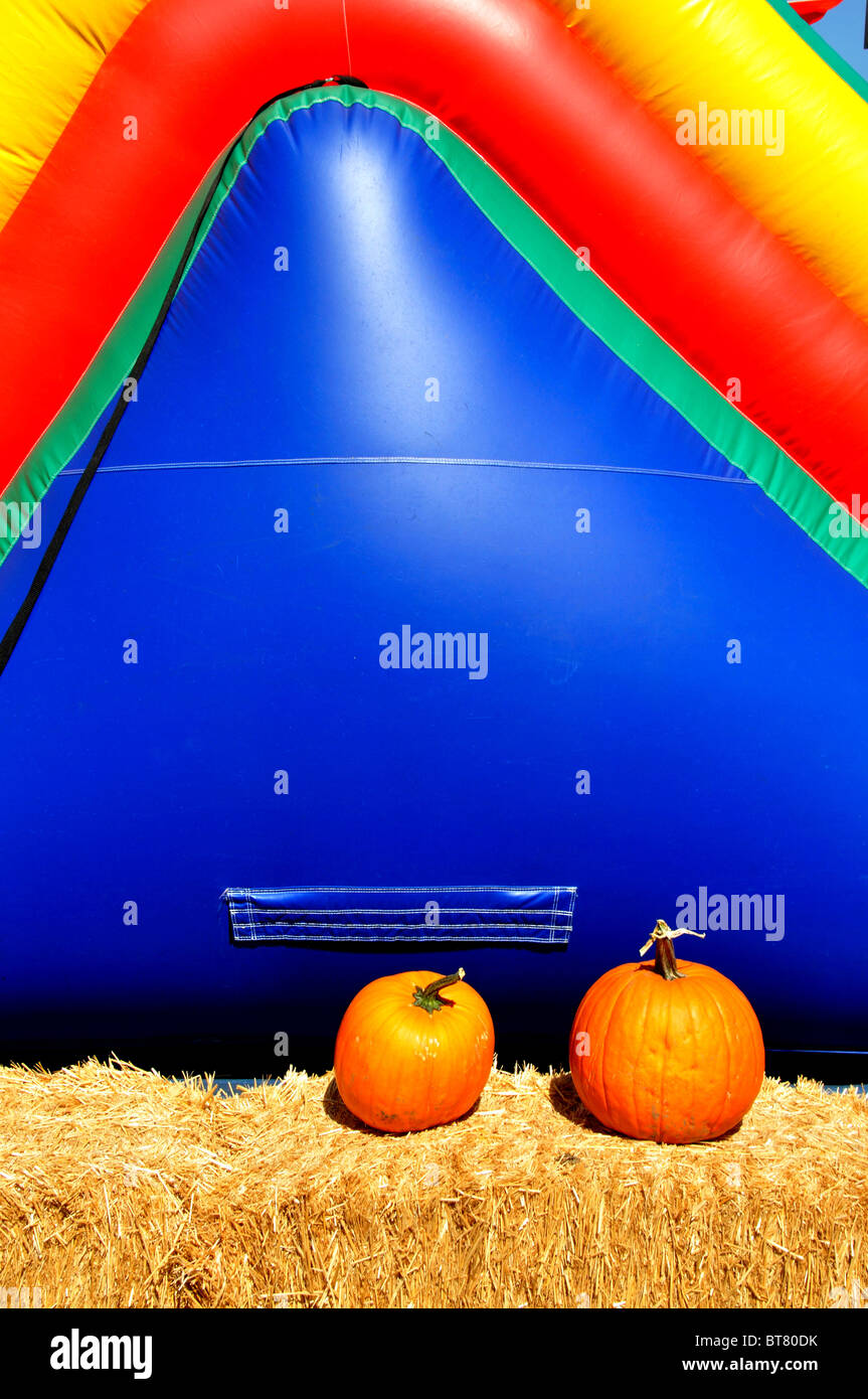 Pumpkins on hay bales in front of an inflatable jumper Stock Photo - Alamy