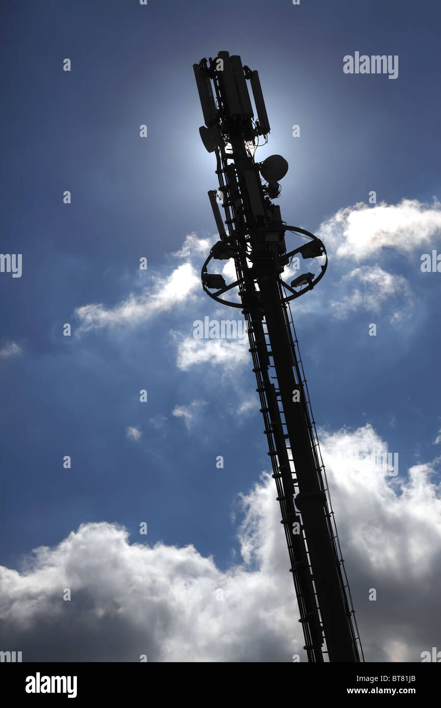 Mobile phone mast silhouetted against blue sky and clouds Stock Photo ...