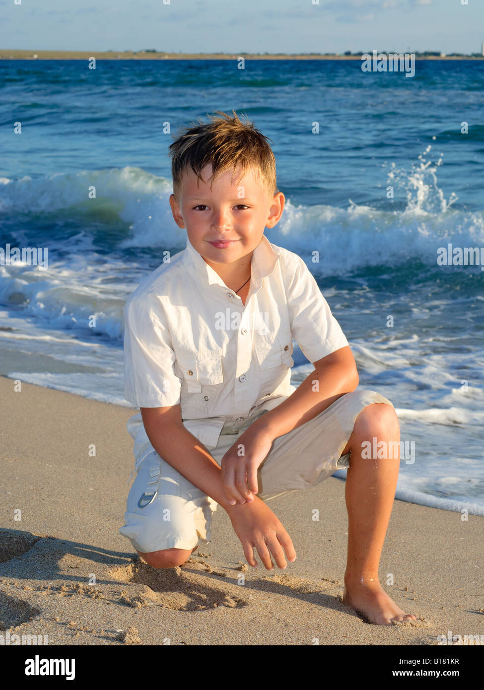 Portrait of a little smiling boy standing at the beach Stock Photo - Alamy