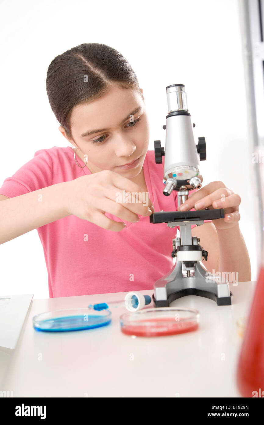 Girl using a microscope, working in a laboratory Stock Photo - Alamy