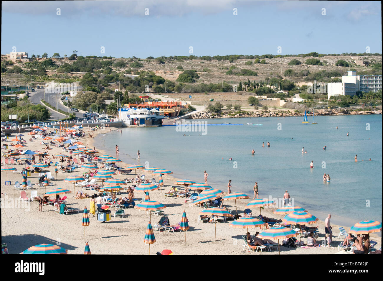Sun worshipers enjoy the sandy beach and the clear shallow water at ...