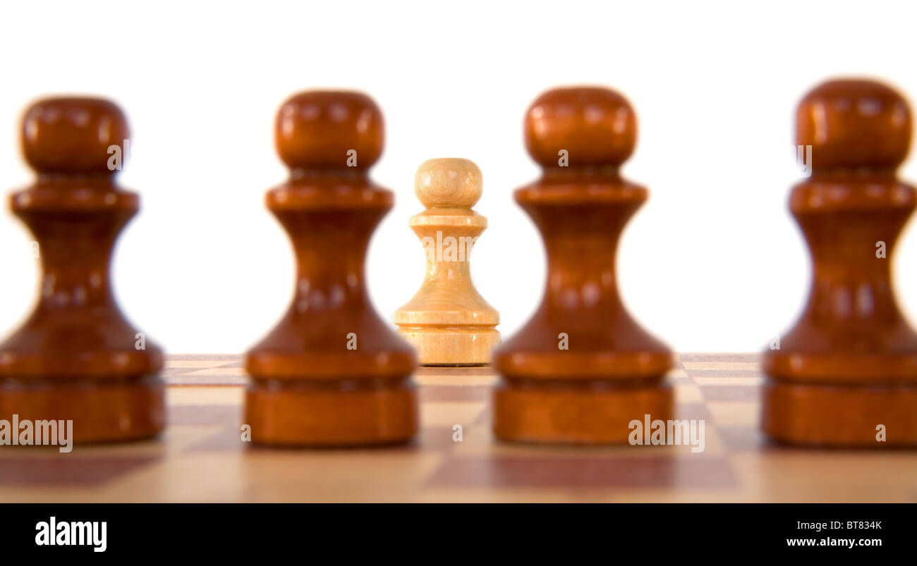 Wooden dark brown pawns and one beige pawn Stock Photo - Alamy