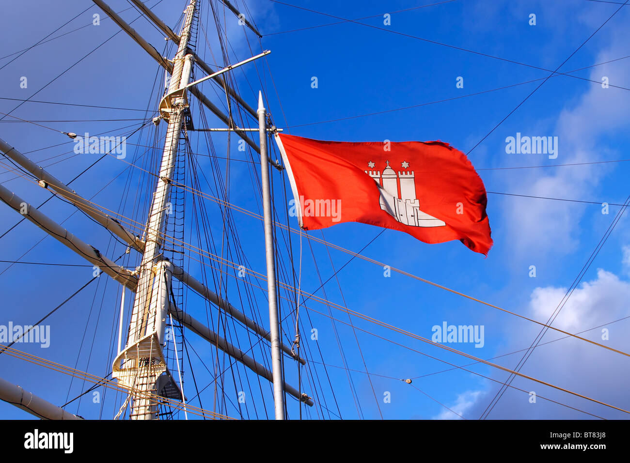 Red flag of Hamburg in front of the mast and rigging of the historic ...