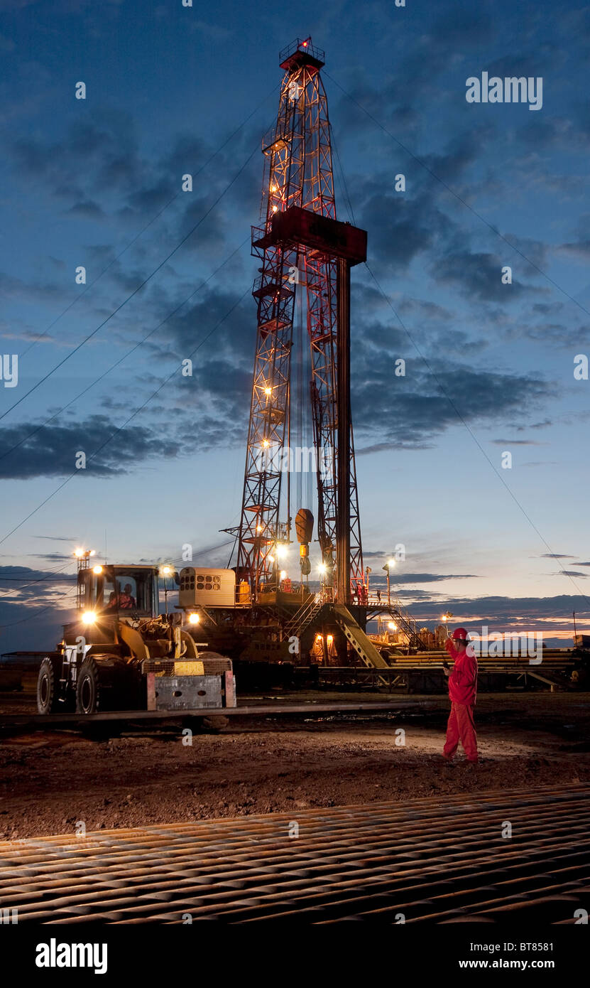 Onshore oil and gas exploration site. Front end loader moving casings ...