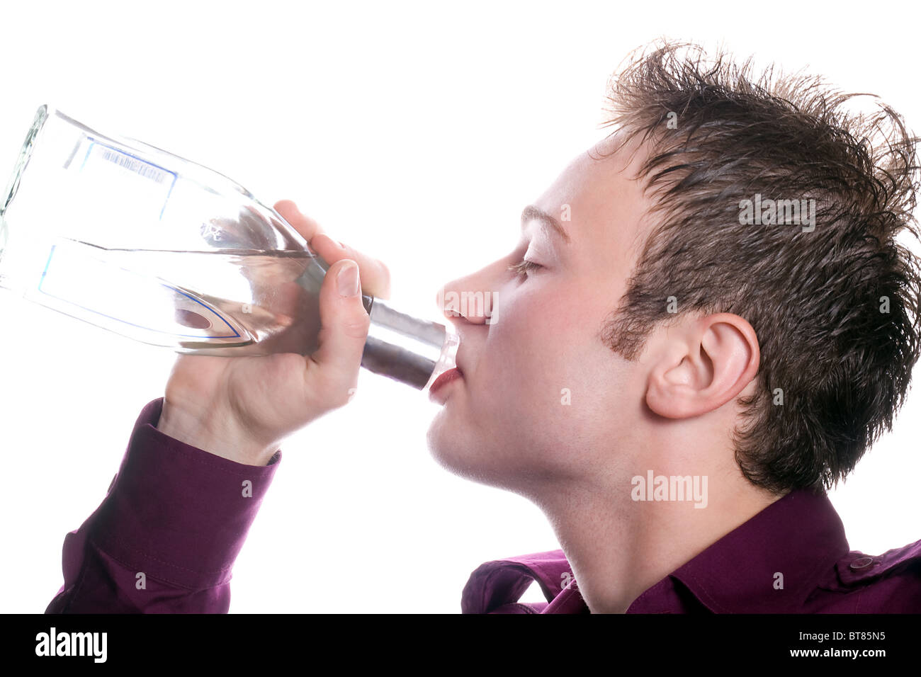 The young man drinks vodka from a bottle Stock Photo - Alamy