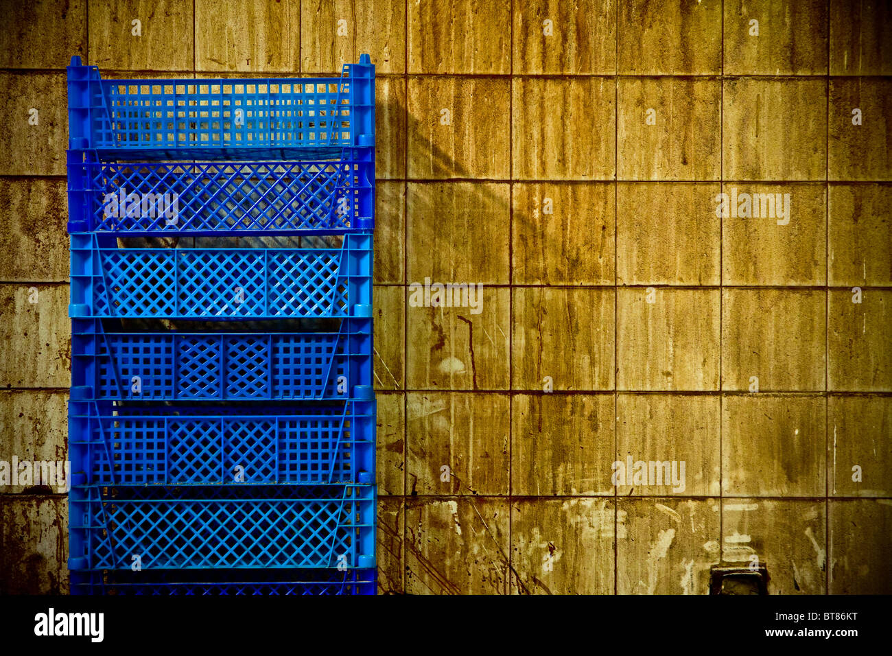 Stacked blue boxes by a very dirty wall Stock Photo - Alamy