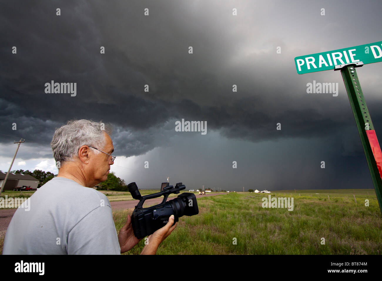 Storm chaser and scientist Tim Marshall videotapes a developing tornado ...
