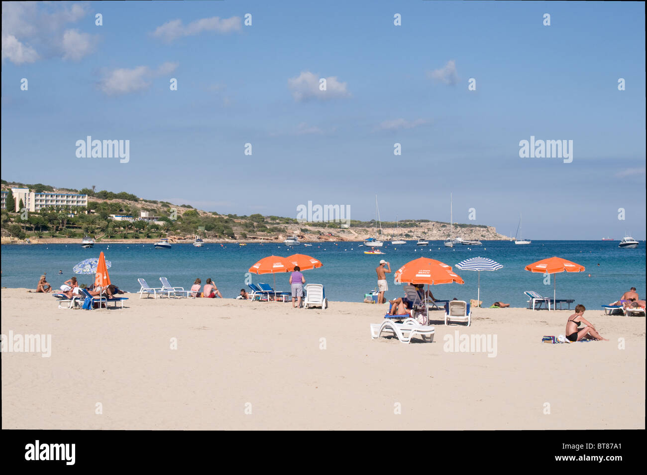 Sunworshipers enjoy the sandy beach and the clear shallow water at ...