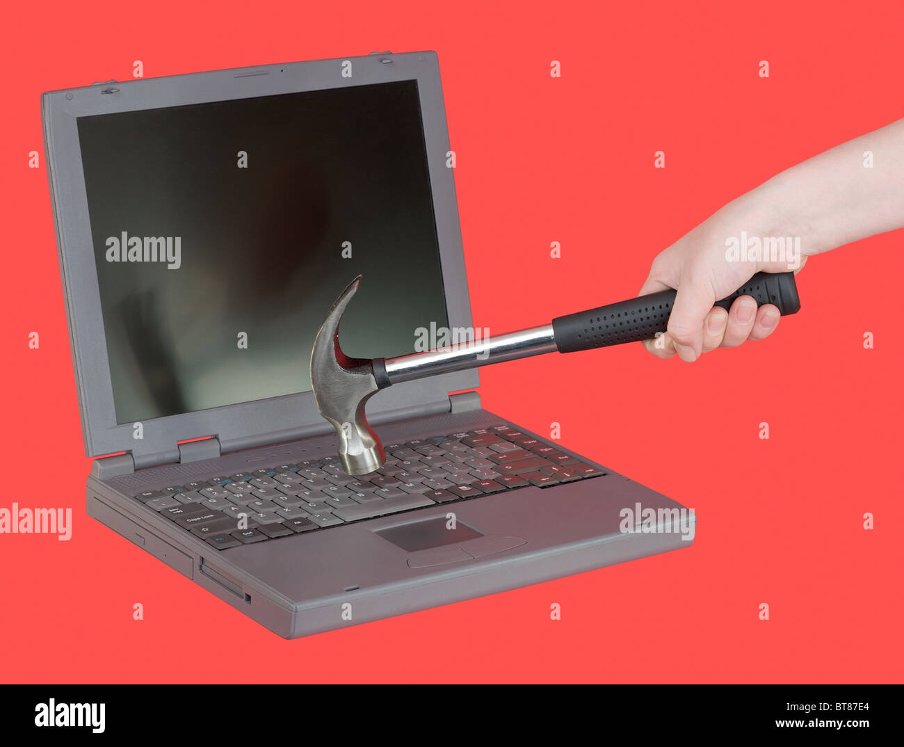 The laptop and hammer on female hand Stock Photo - Alamy