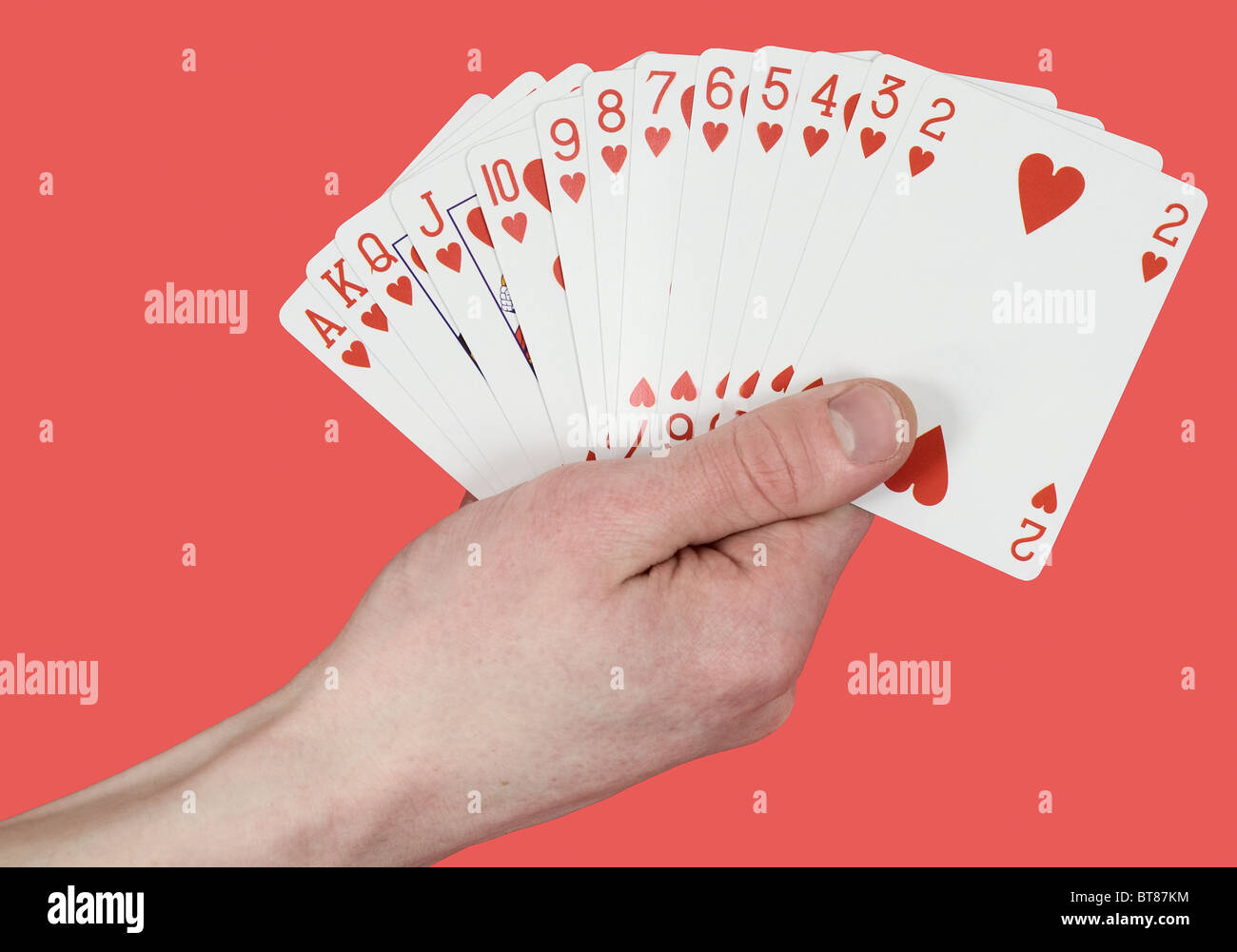 Playing cards on hand on the red background Stock Photo - Alamy
