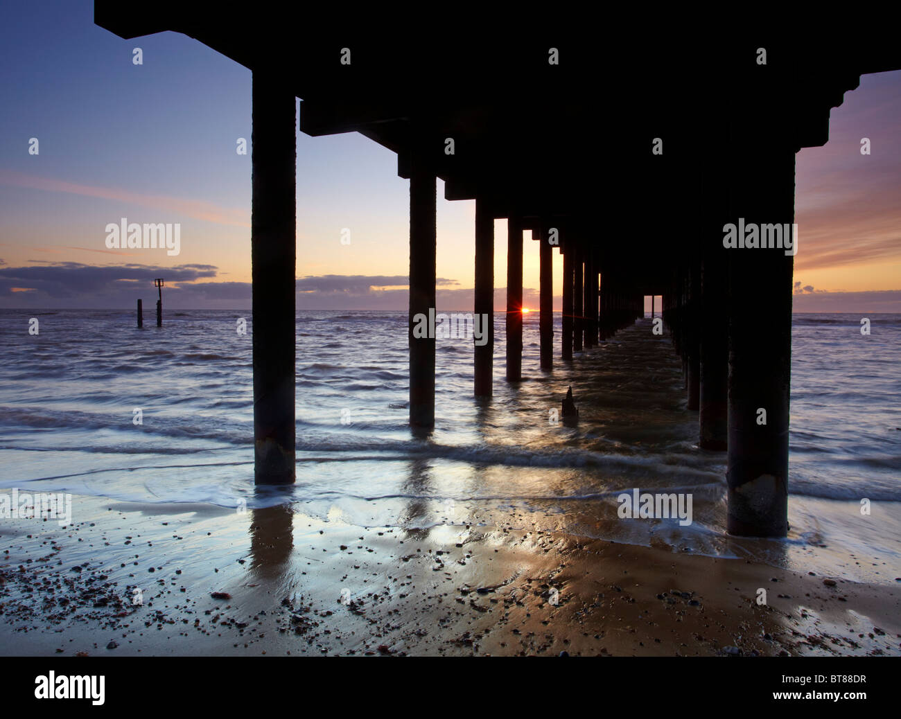 The rising sun pictured between the legs of Southwold Pier on the ...