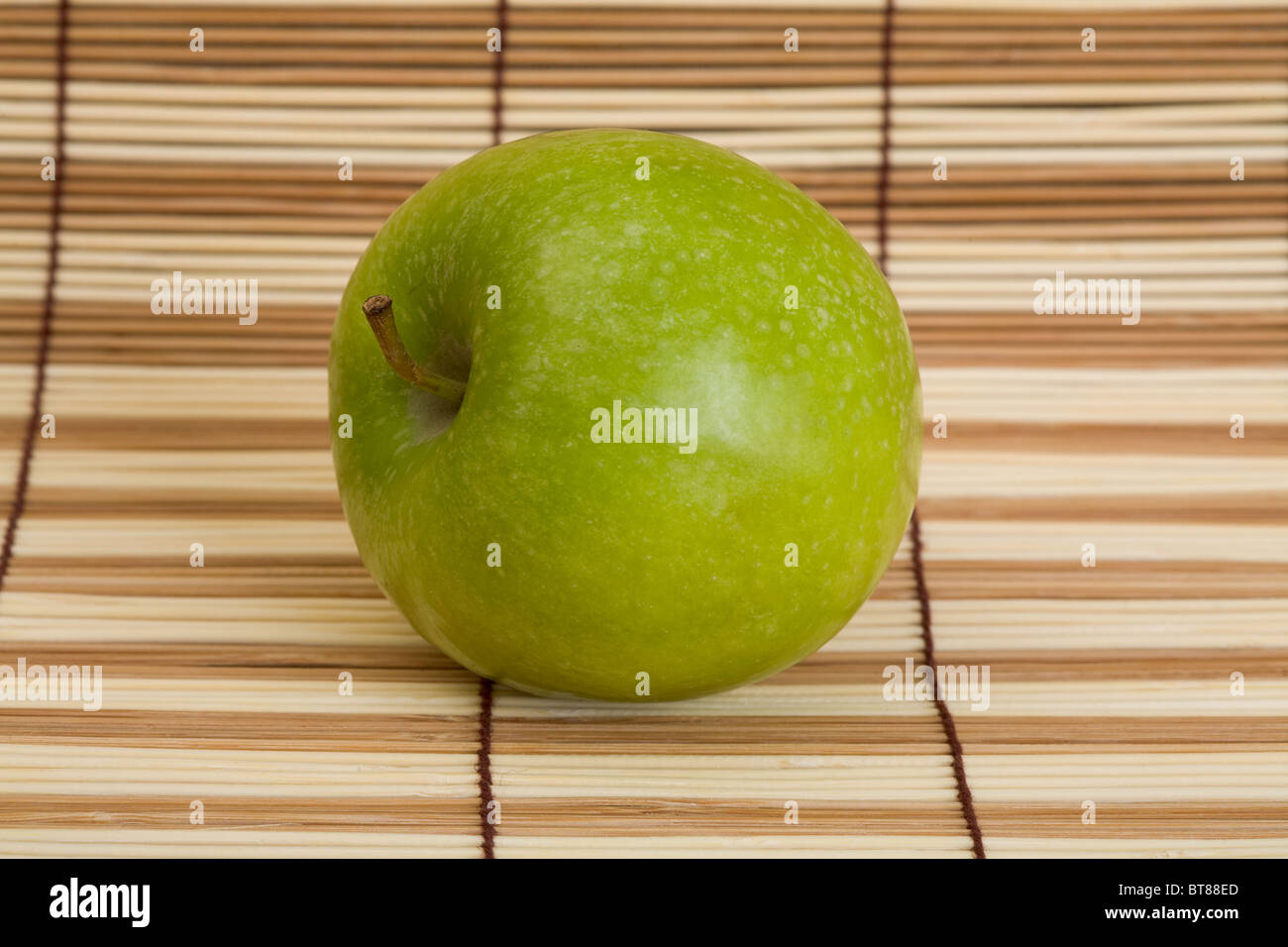 Big green apple on the wooden mat Stock Photo - Alamy