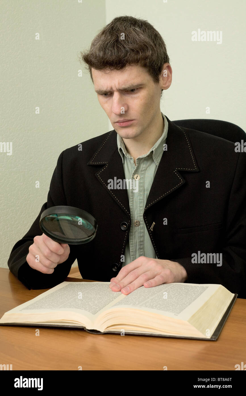 Man in black suit read book on a workplace Stock Photo - Alamy