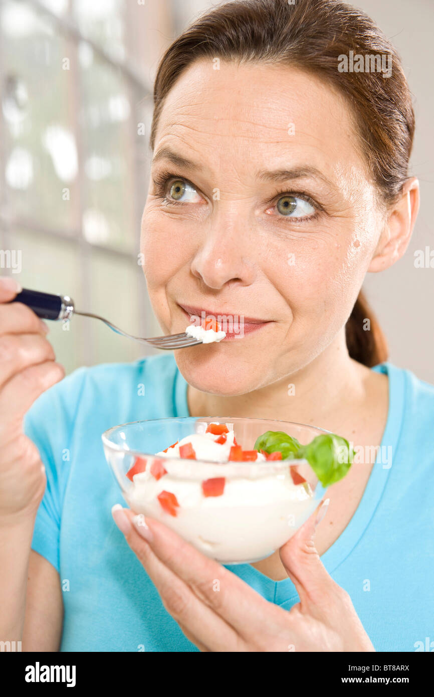 Woman eating quark Stock Photo - Alamy