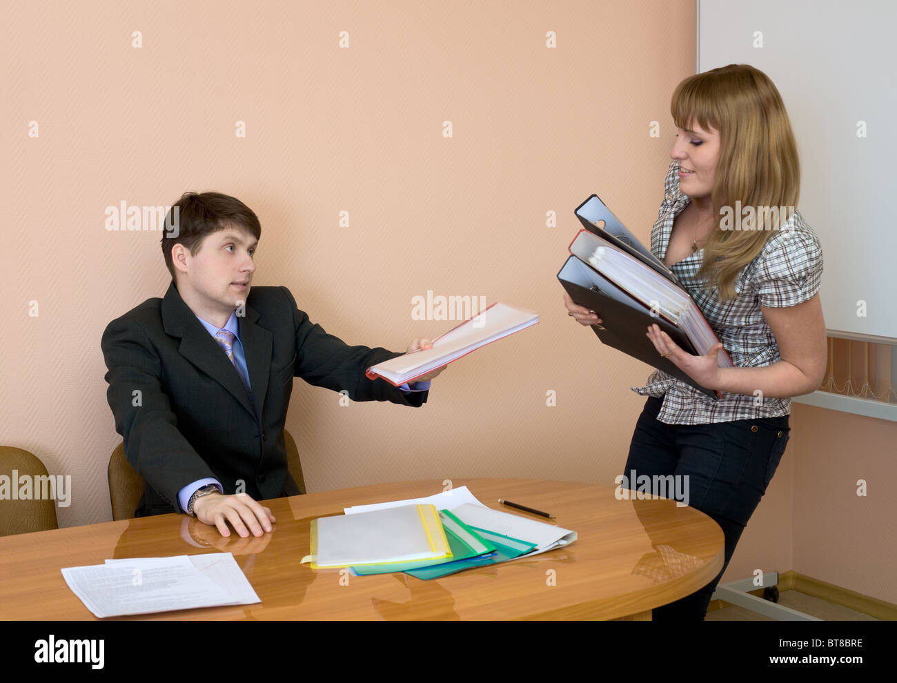 The secretary gives a folders to the chief Stock Photo - Alamy