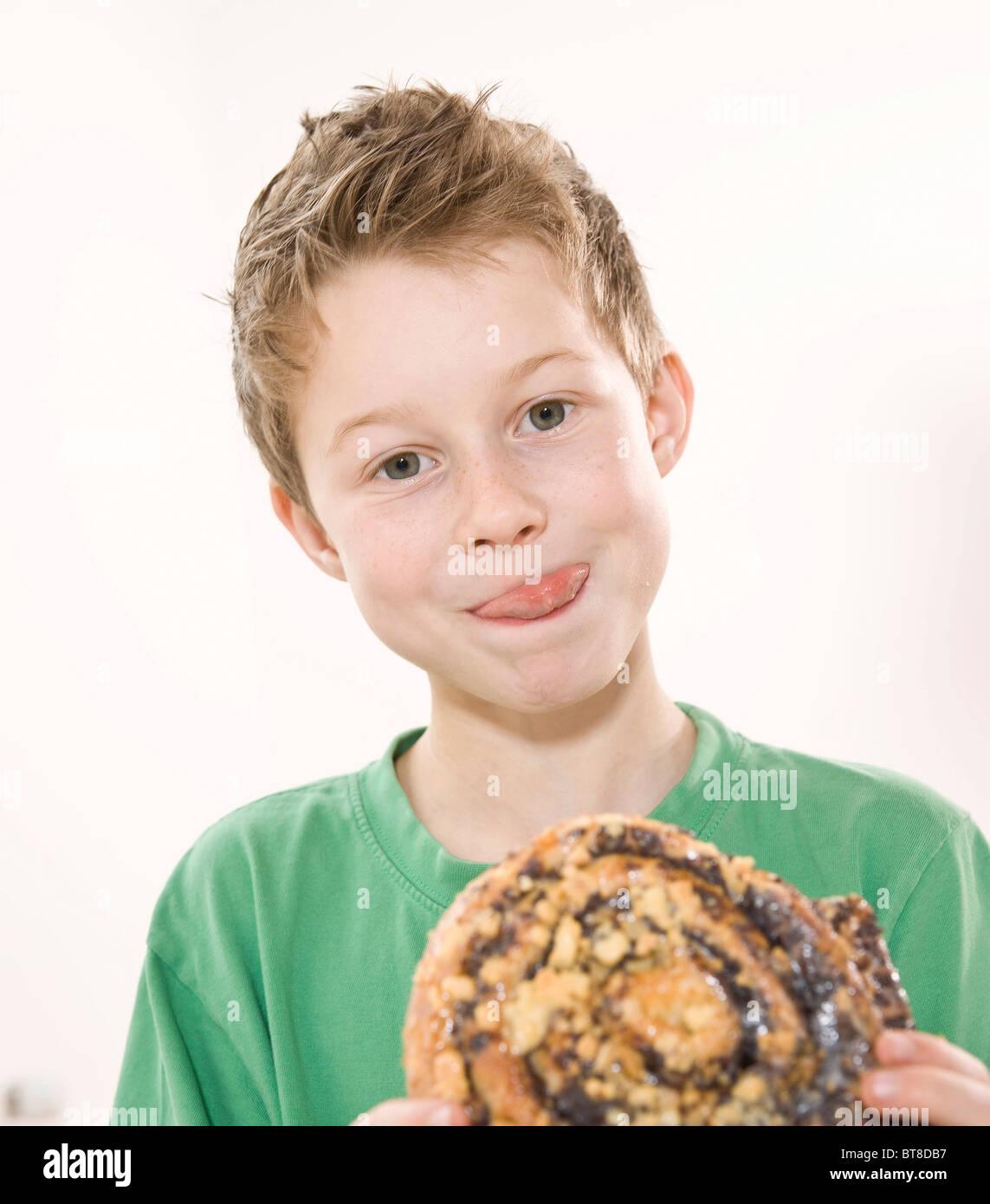 Boy delightfully eating a poppy seed pastry Stock Photo - Alamy