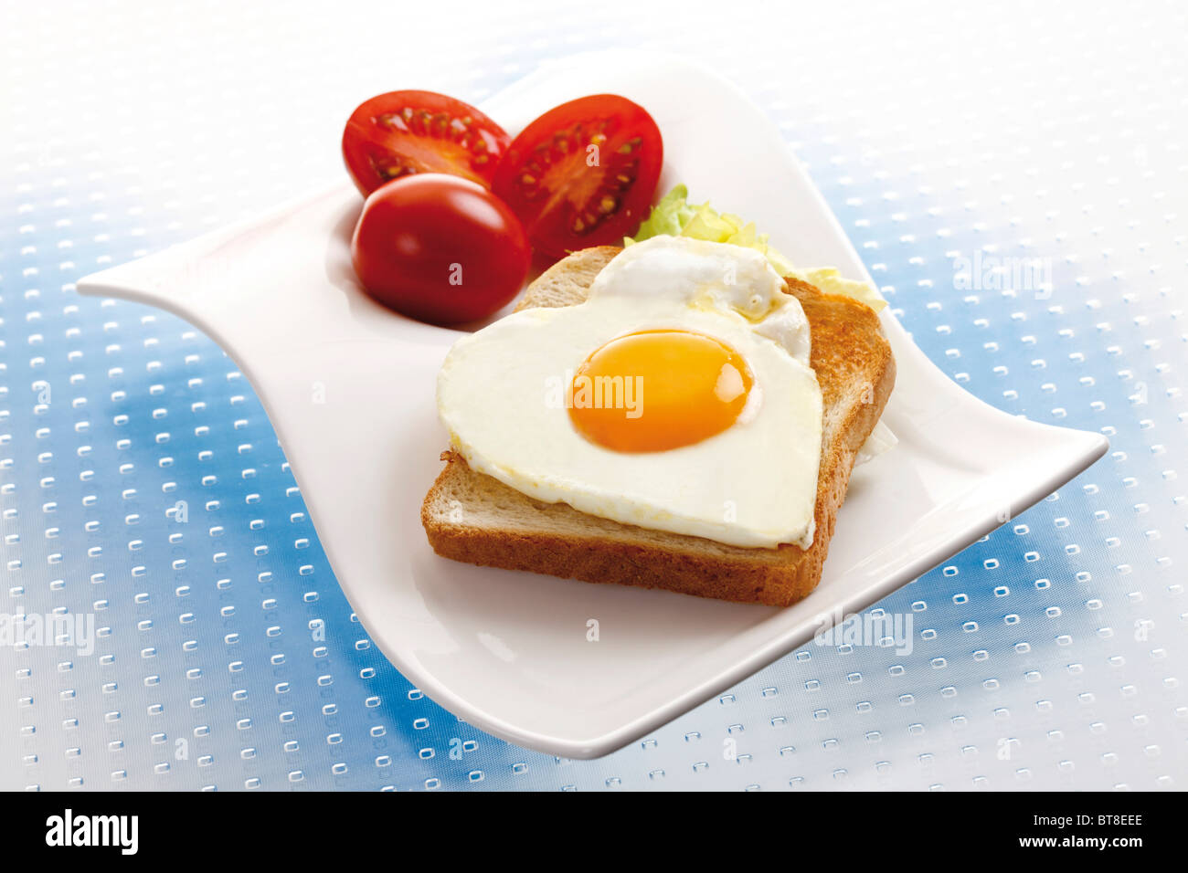 Toast with heart-shaped fried egg and tomatoes Stock Photo - Alamy