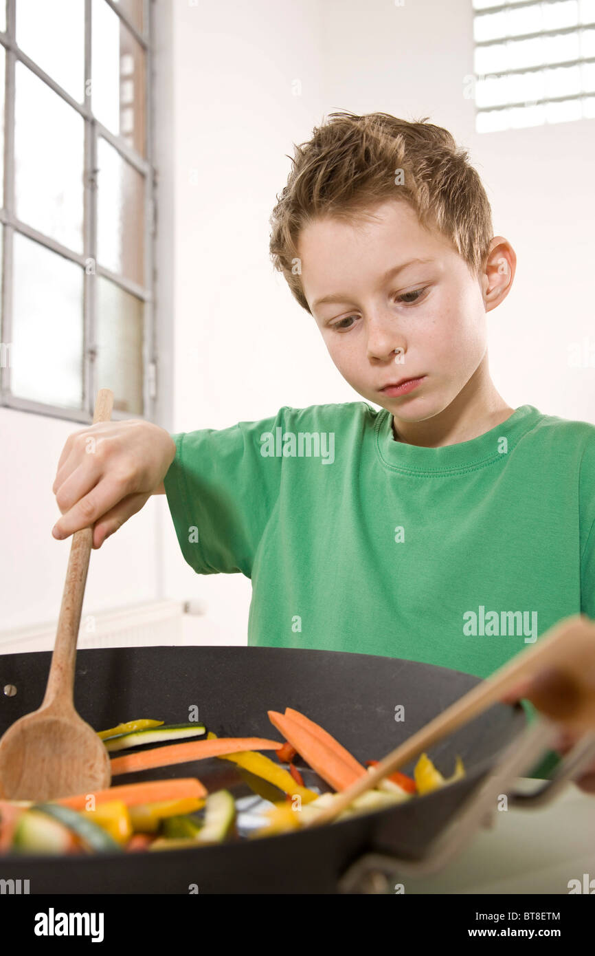 Boy cooking vegetables in a wok Stock Photo - Alamy